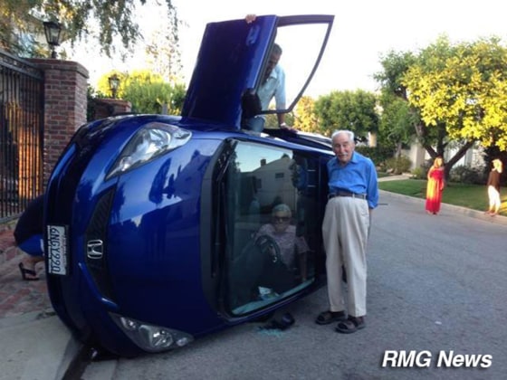 Elderly Couple Poses for Photo After Car Flips