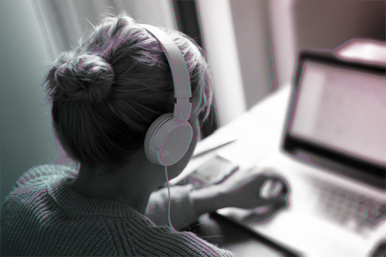 woman with headphones working on notebook computer