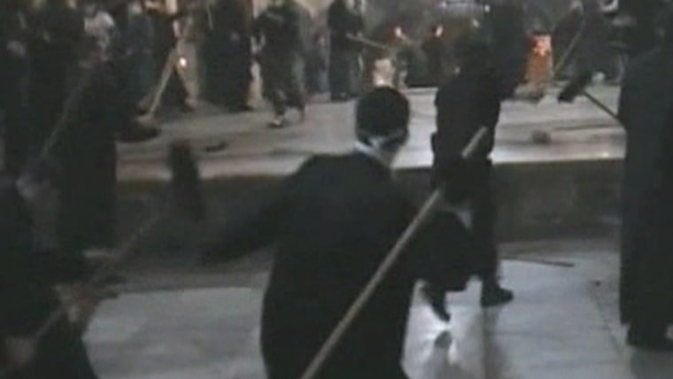 Priests and monks fight with brooms at church