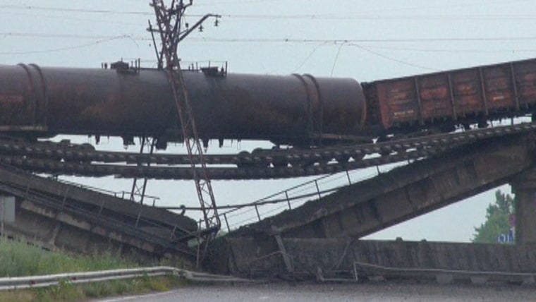 Train Hangs Over Road After Explosion Hits Bridge