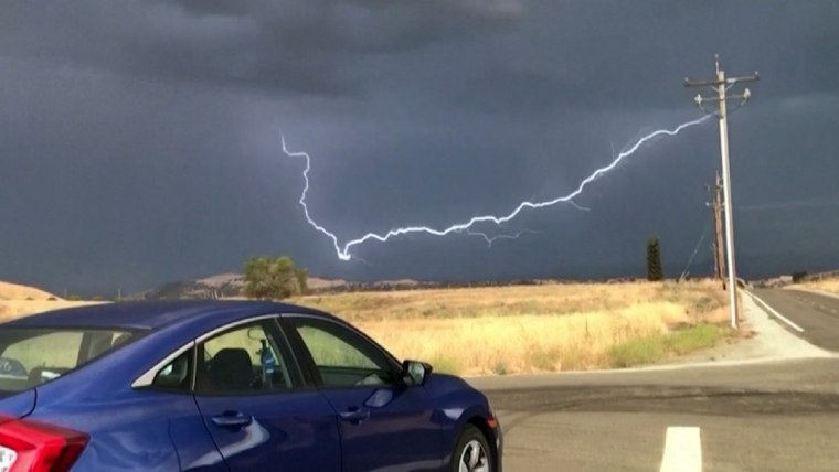 Lightning strikes over rainbow in stormy California sky