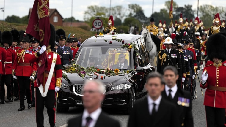 Members of Queen Elizabeth’s staff march alongside her coffin
