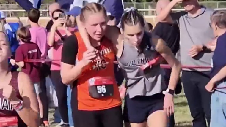 Arkansas runner helps competitor cross finish line