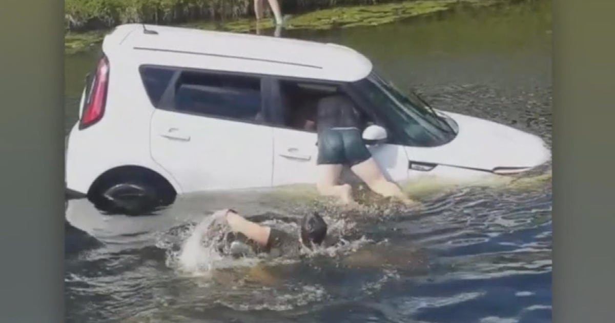 Watch man rescue driver from sinking car
