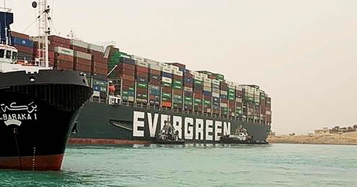 Tug boats struggle with giant container ship blocking Suez Canal
