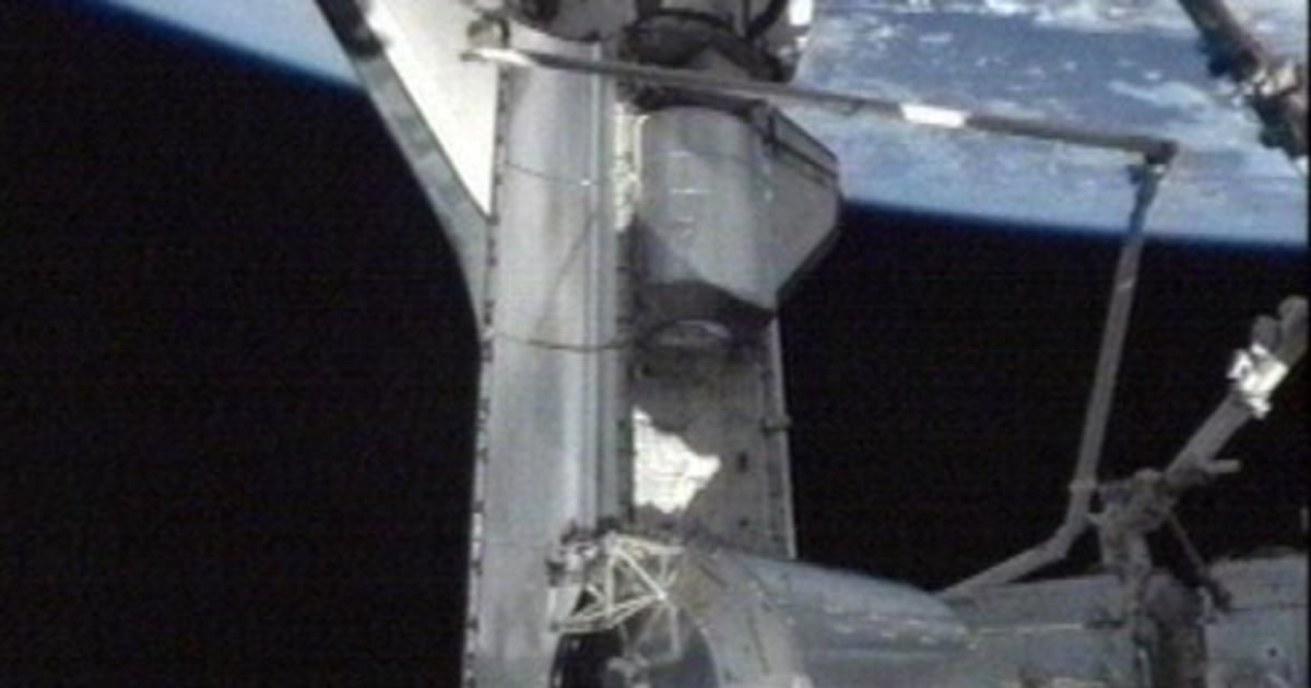 Astronauts load cargo carrier on space shuttle