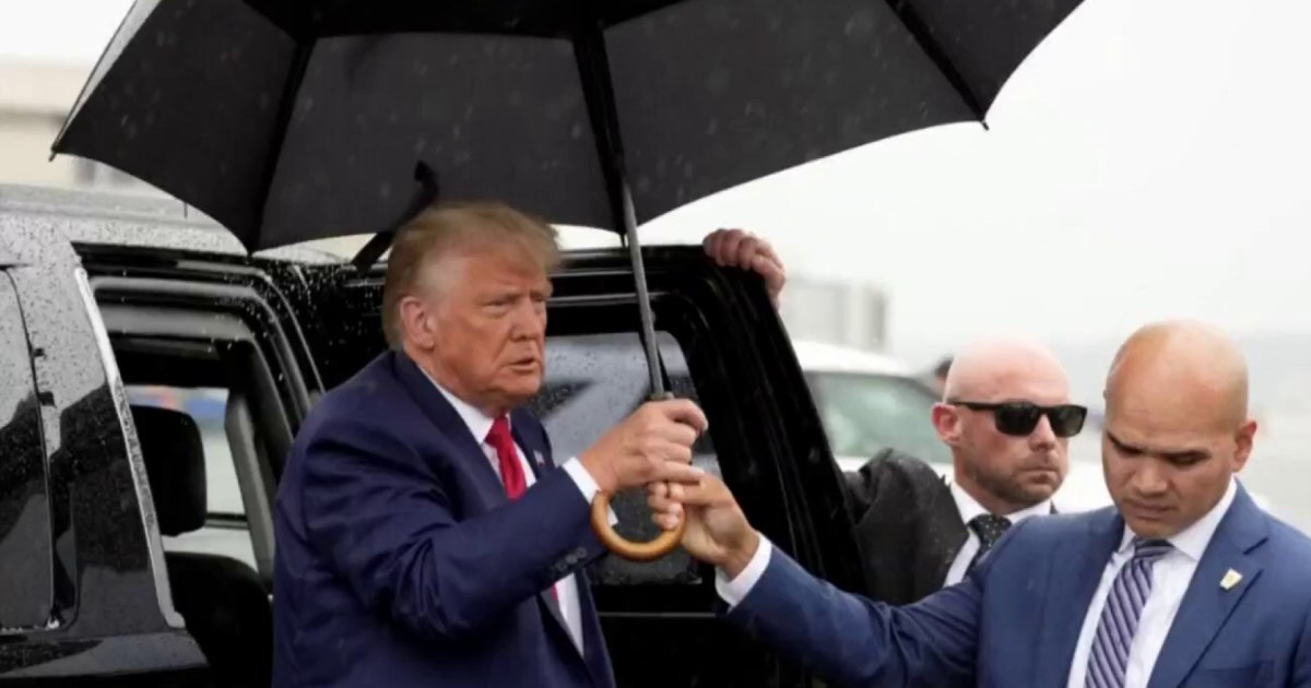Walt Nauta holds umbrella for Trump after arraignment