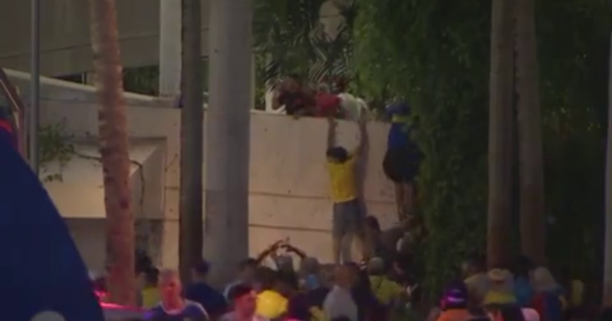 Fans climb over security railings at Copa America final