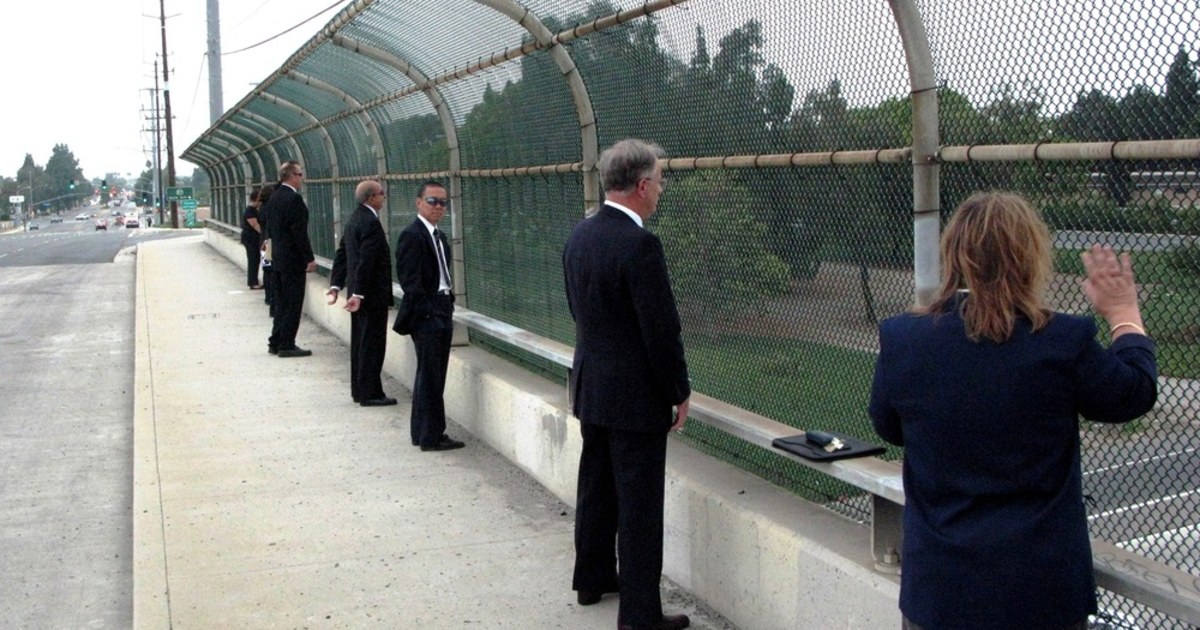 Workers face cars from California freeway overpass in silent protest