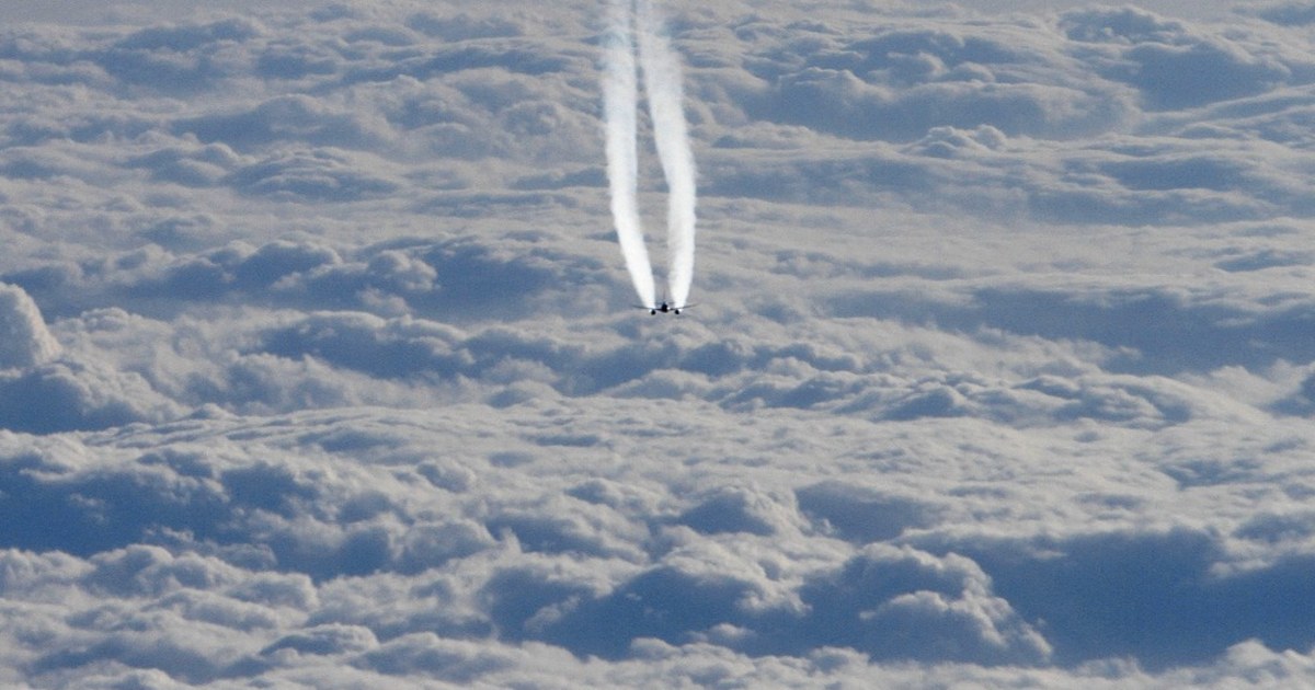 Uncommon head-on view of jet in flight, and its contrail
