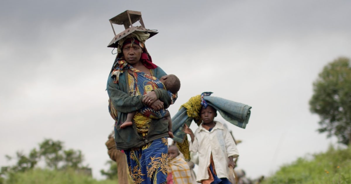 Displaced villagers march with their belongings to escape Congo fighting