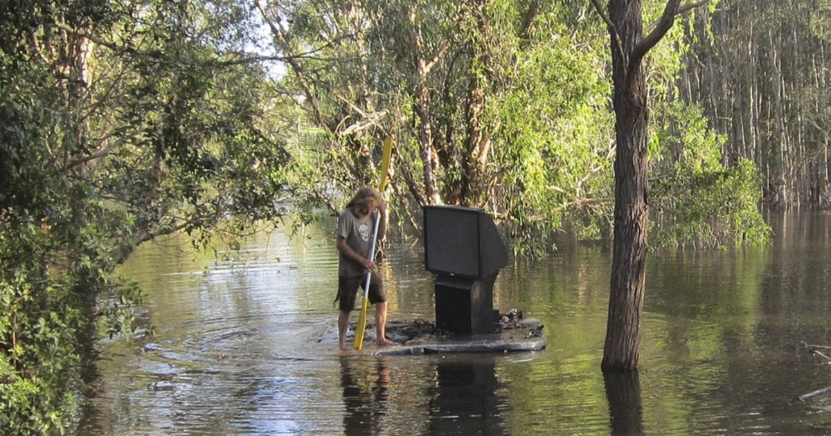 Save the TV! Aussie floats his big screen to safety from floodwaters