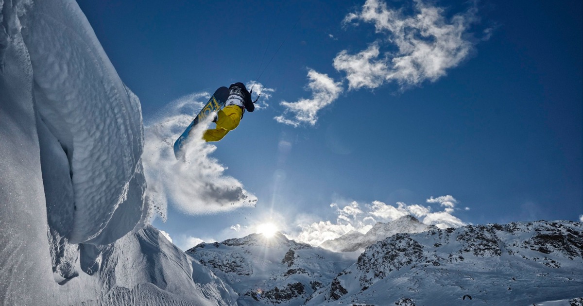 Snowkiter catching air in Swiss Alps