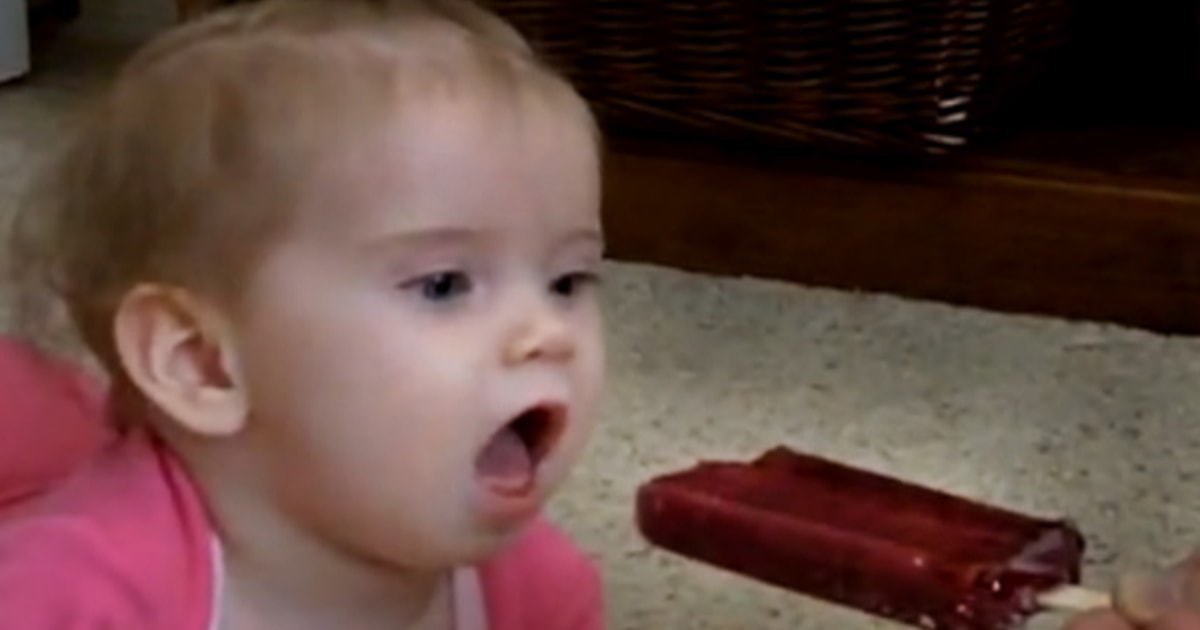 Determined baby inches toward popsicle