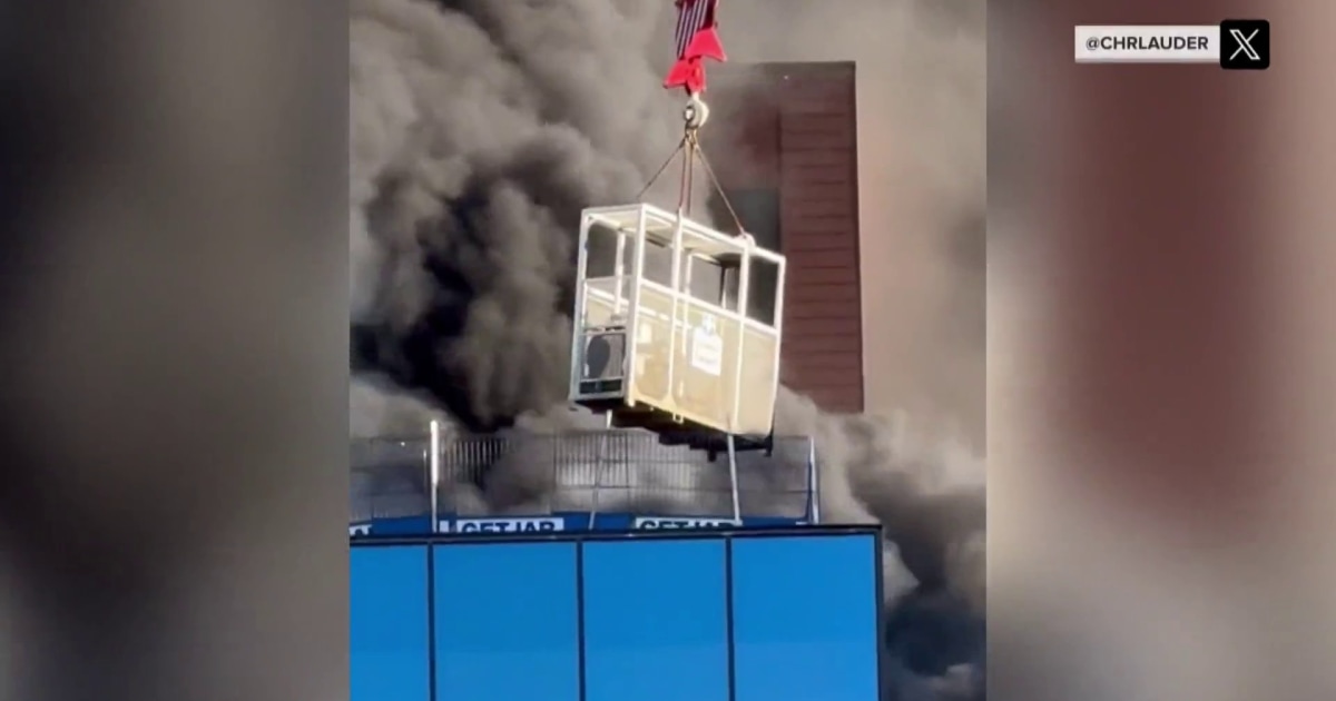 Watch: Crane operator rescues worker from burning high-rise