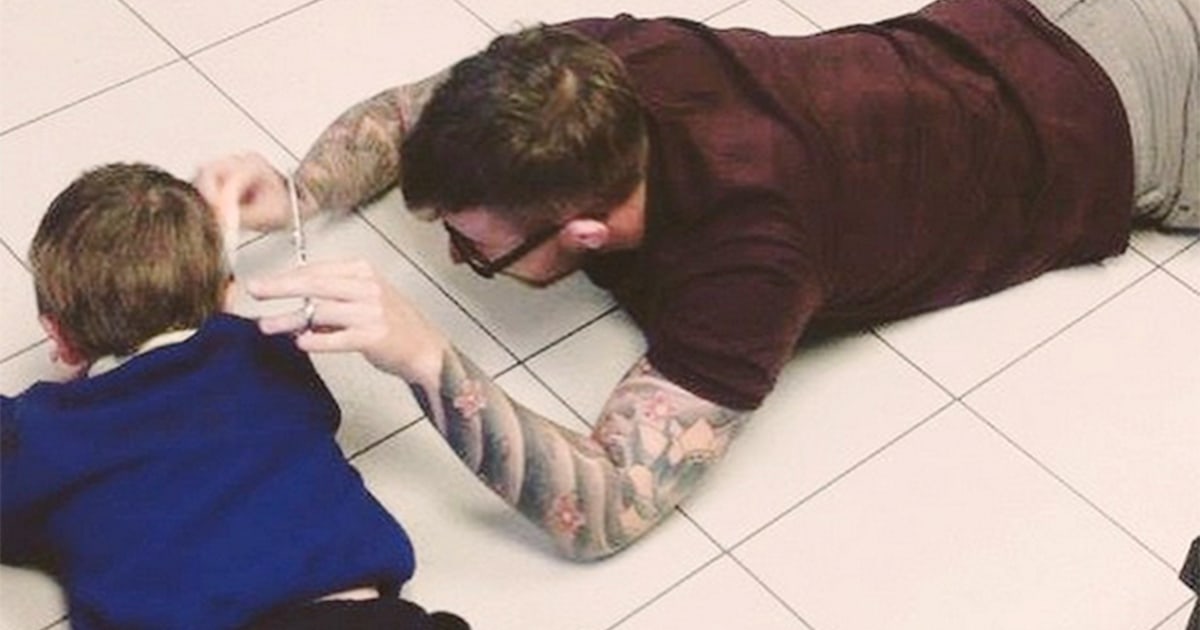 Barber gets on the ground to give trauma-free trim to child with autism