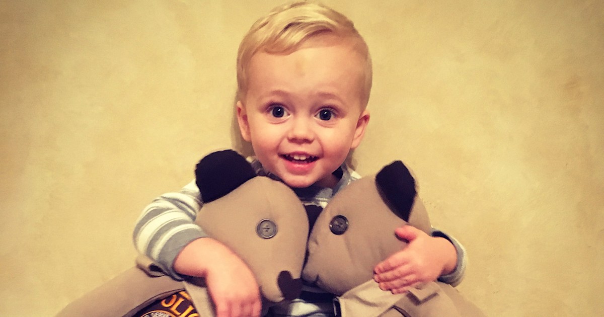 Slain officer's son hugs teddy bears made from dad's uniform
