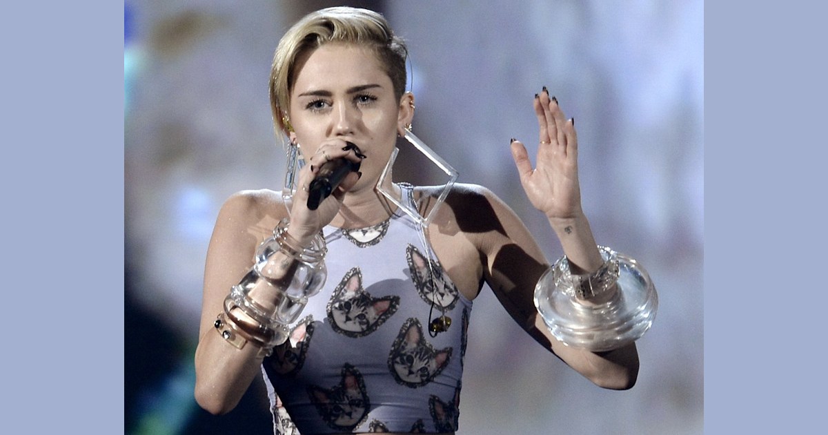 Meowza! Miley Cyrus rocks out with a fuzzy kitten at American Music Awards